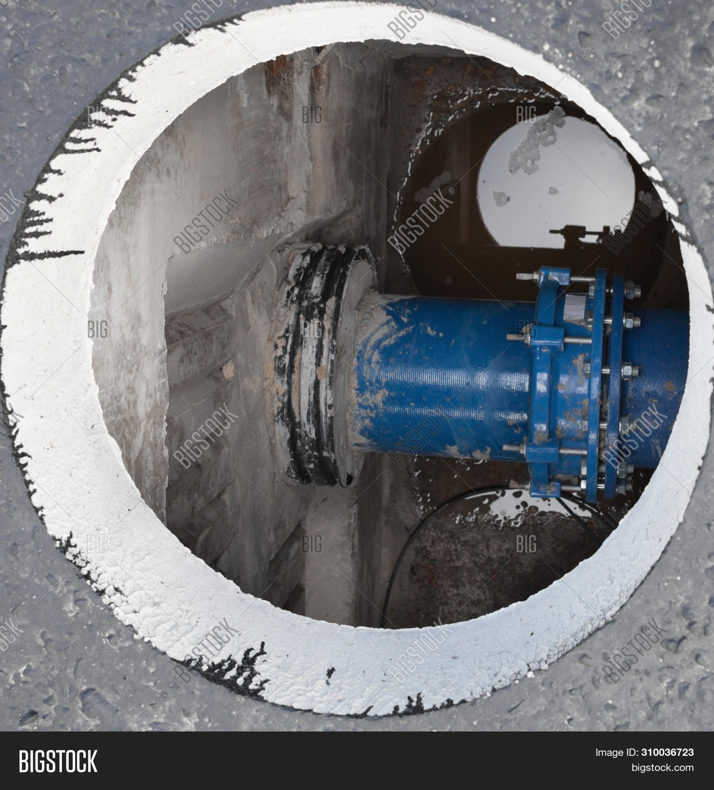 Open Manhole In The Concrete Block. Blue Pipe In The Manhole. Coupling ...