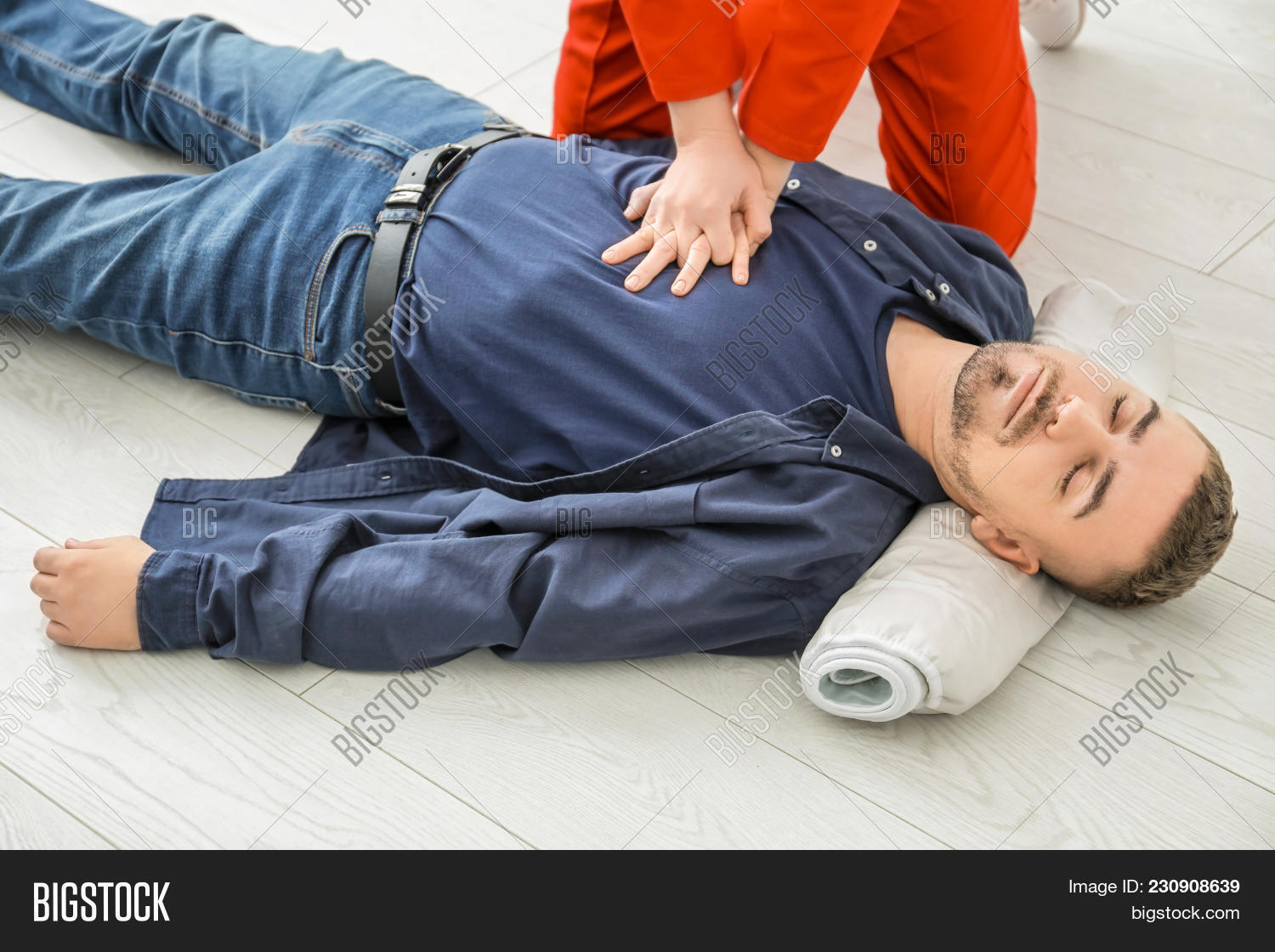 Young woman giving first aid to unconscious man on floor, indoors image ...