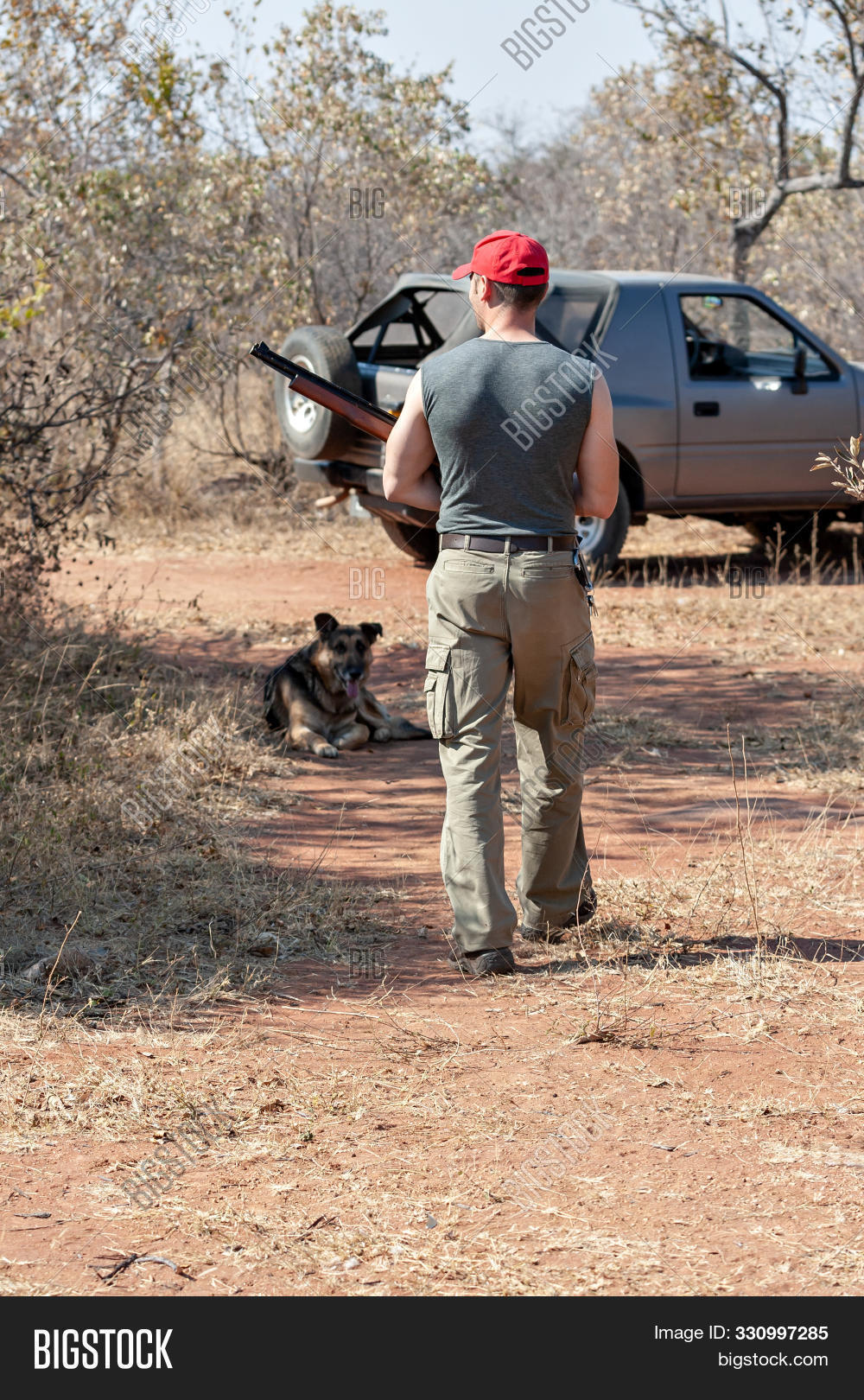 Caucasian south african hunter in the bush with his dog, riding a 4x4 ...