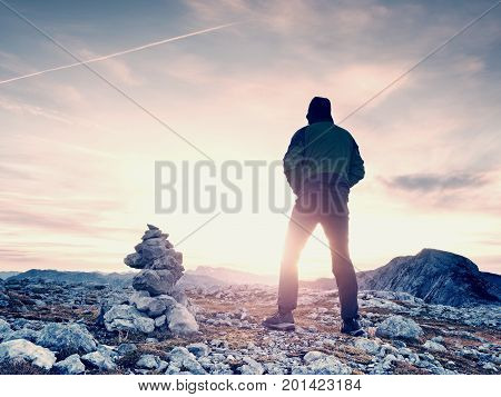 Tourist Guide At Stocked Stones On Alps Peak. Strong Hiker Enjoy Sunset ...