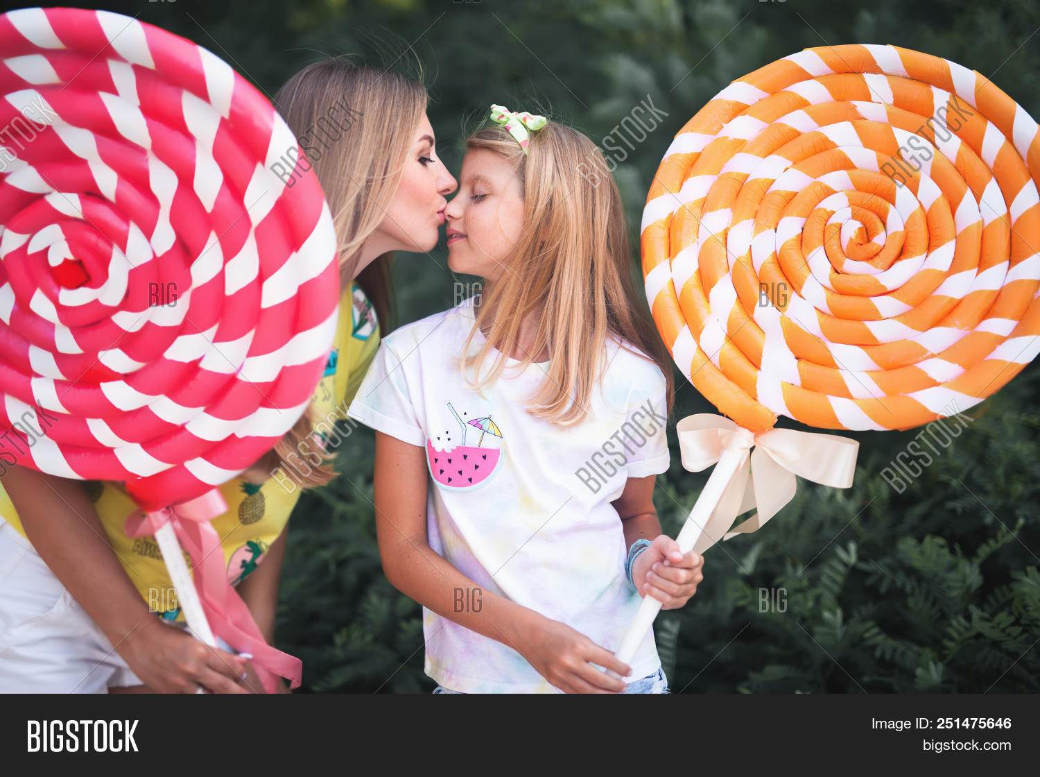 Blonde Mum Kissing Her Daughter. Girl Holding A Big Chupa Chups. Love ...