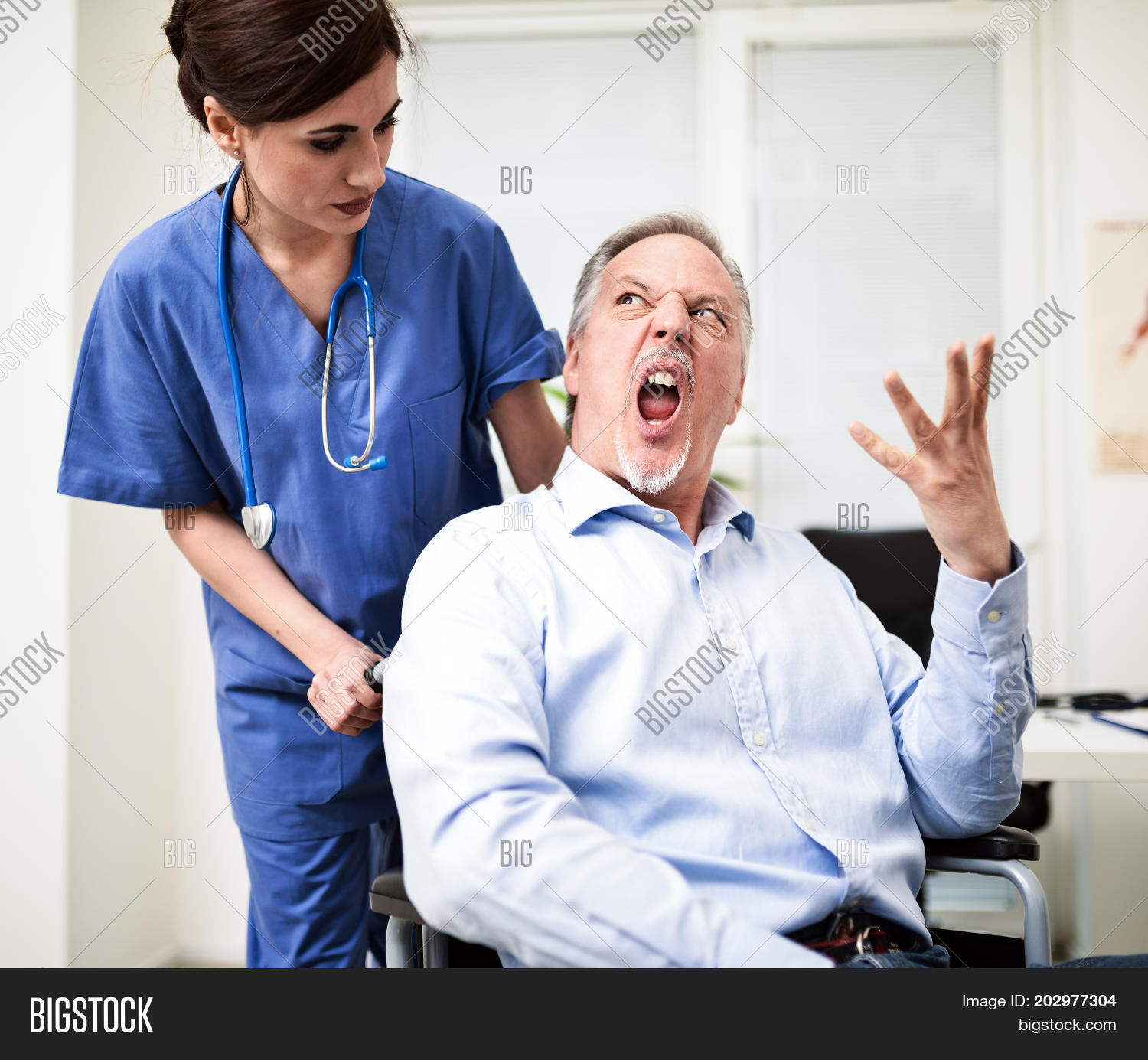 Patient on a wheelchair getting angry with nurse image & stock photo ...