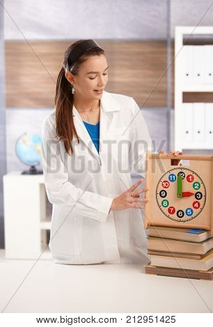 Young female teacher teaching time and clock in elementary school ...