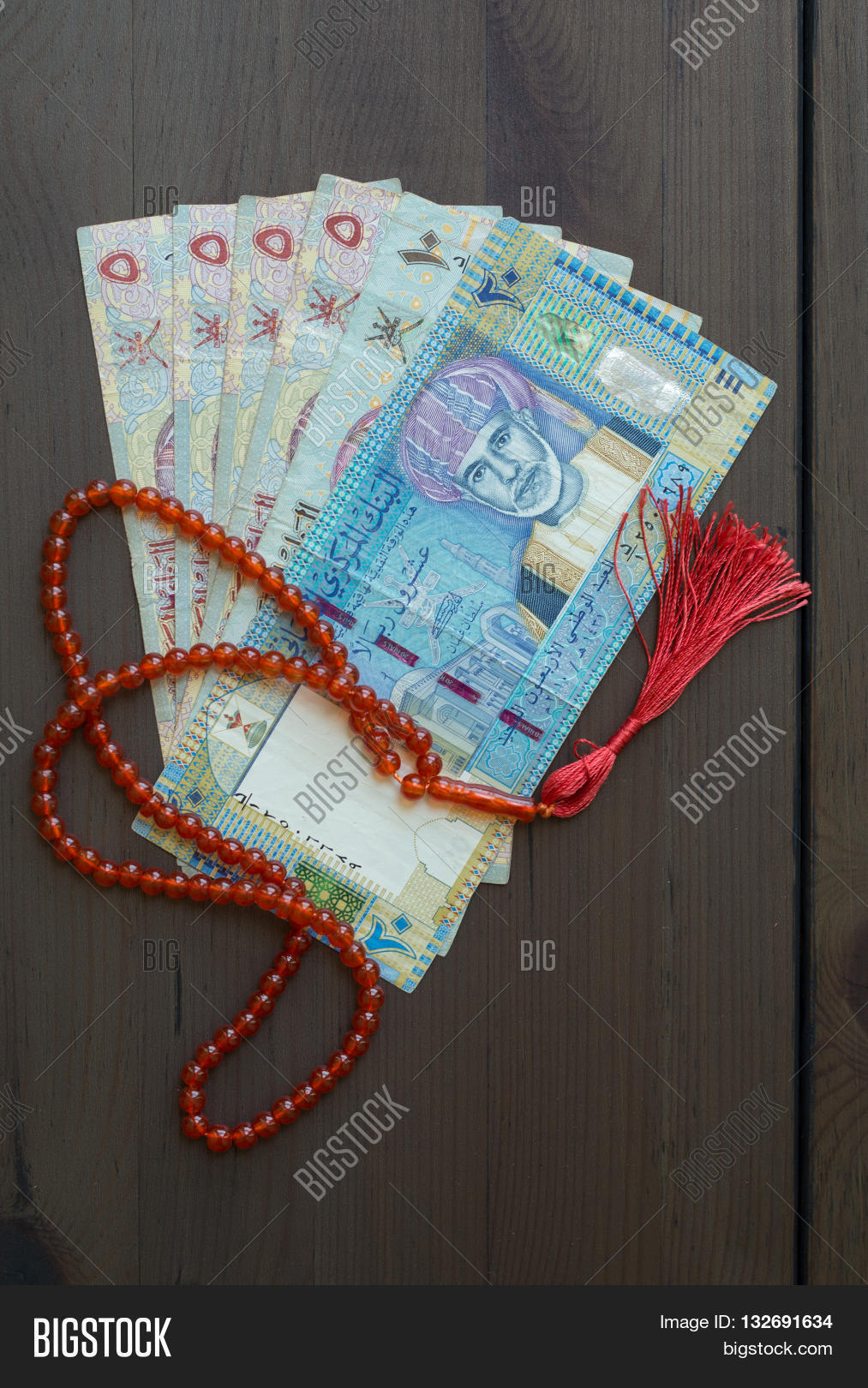 Omani Riyal currency notes and Islamic prayer beads. Sharia'h or ...