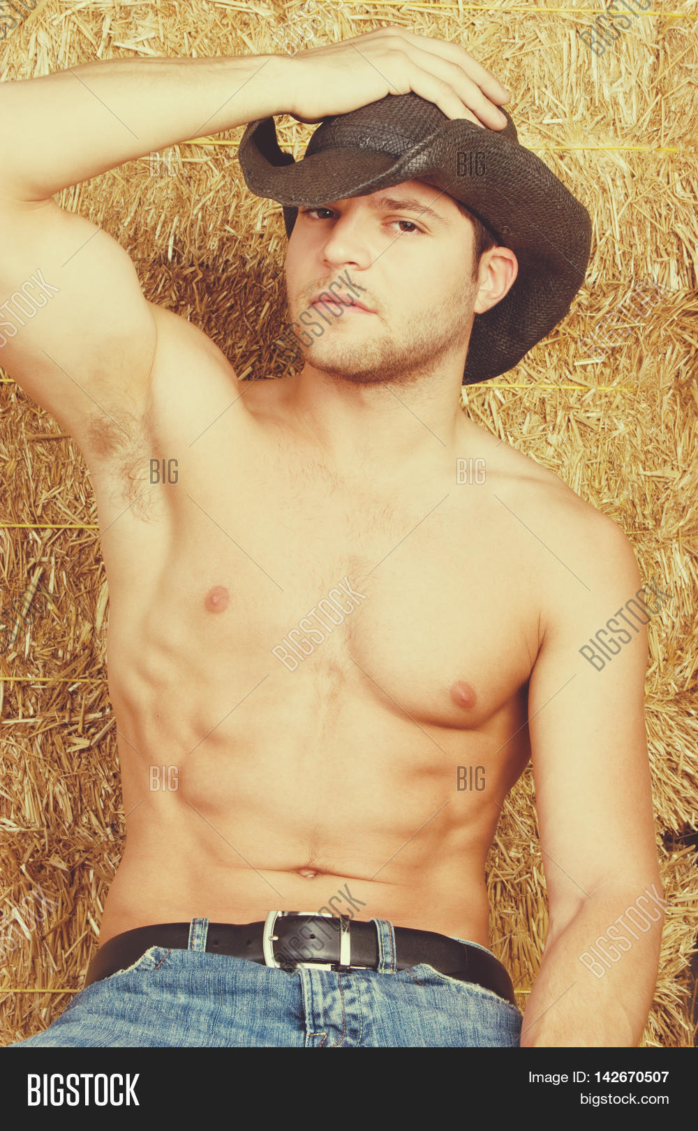 Sexy shirtless cowboy wearing cowboy hat image & stock photo. 142670507