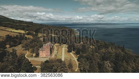 Scotland landscape, medieval castle aerial view: trees and ocean shore ...