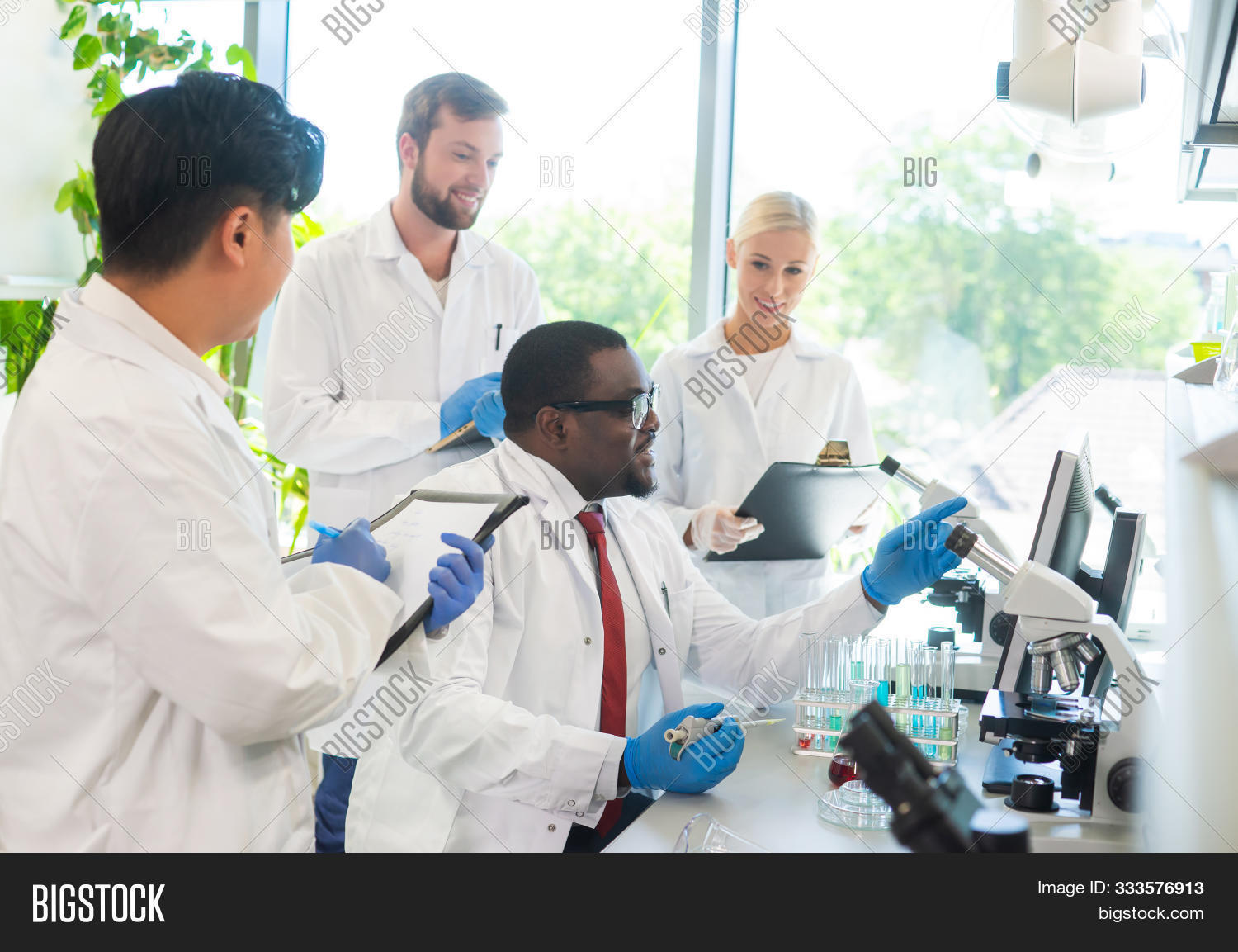 Scientist And Students Working In Lab. Doctor Teaching Interns To Make ...