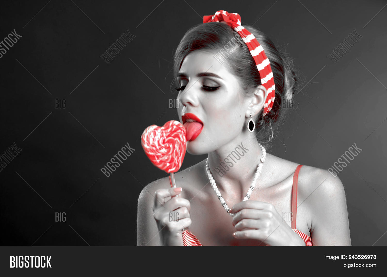 Woman eating lollipops. Girl pin-up style hold striped candy. Female wearing dress girl behaving ...