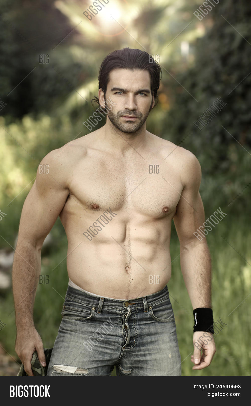 Portrait of a hunky male fitness model shirtless in beautiful outdoor ...