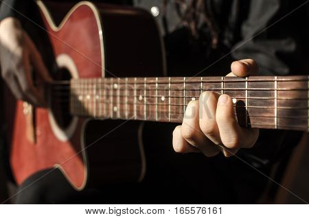 Guitarist with red guitar. The hands on the strings of a guitar ...