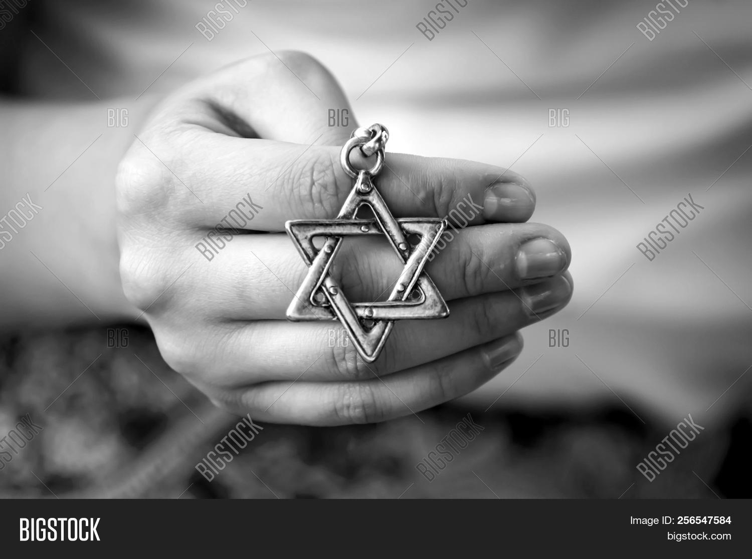 A Hand Of A Young Woman Hand Holding A Star Of David Key Chain. Black ...
