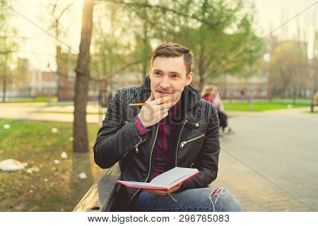 Man With A Notebook In His Hands In The Park. Male, Student Is Writing ...
