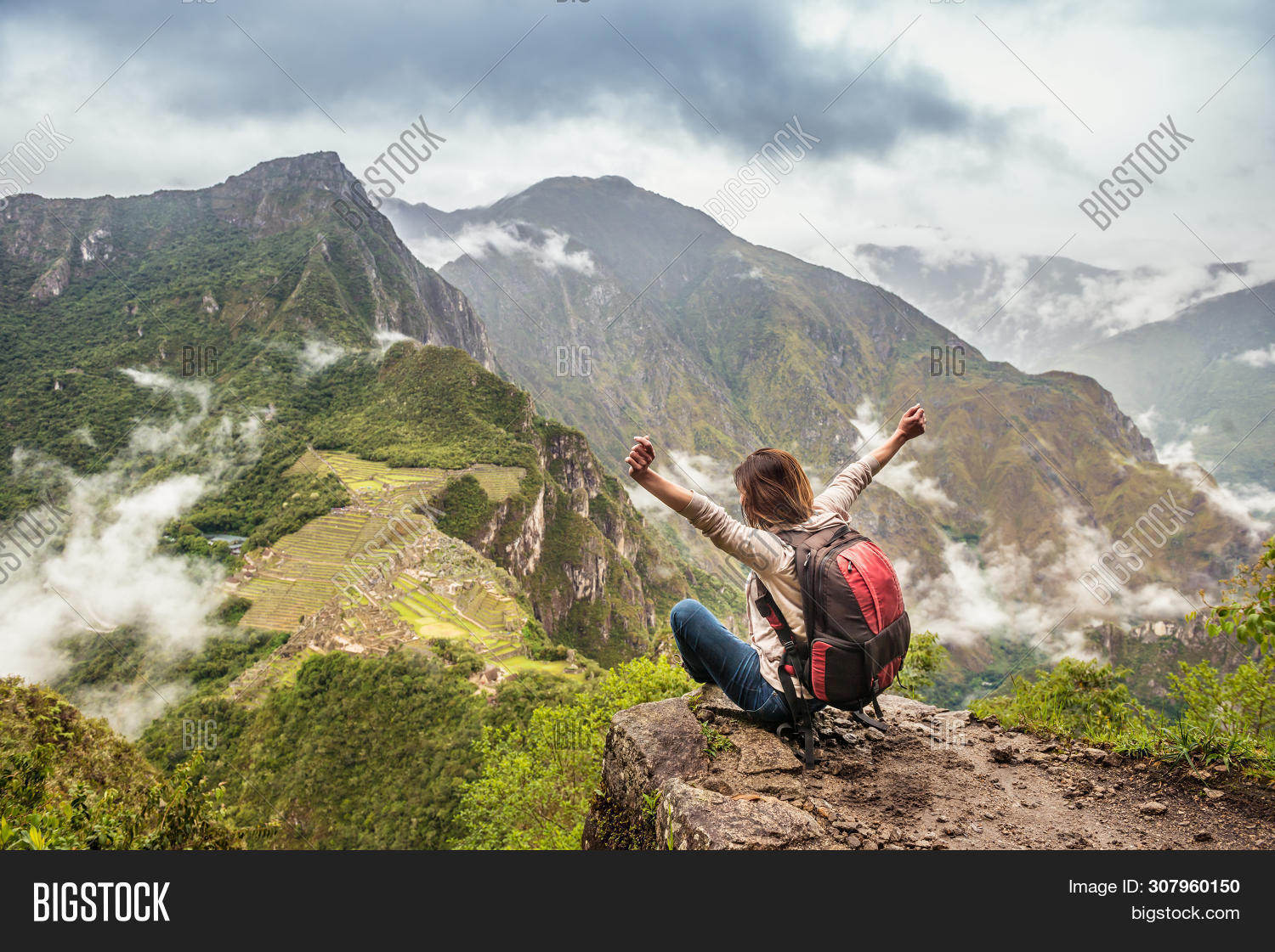 Young woman relaxing on the top of majestic Huayna Picchu mountain ...