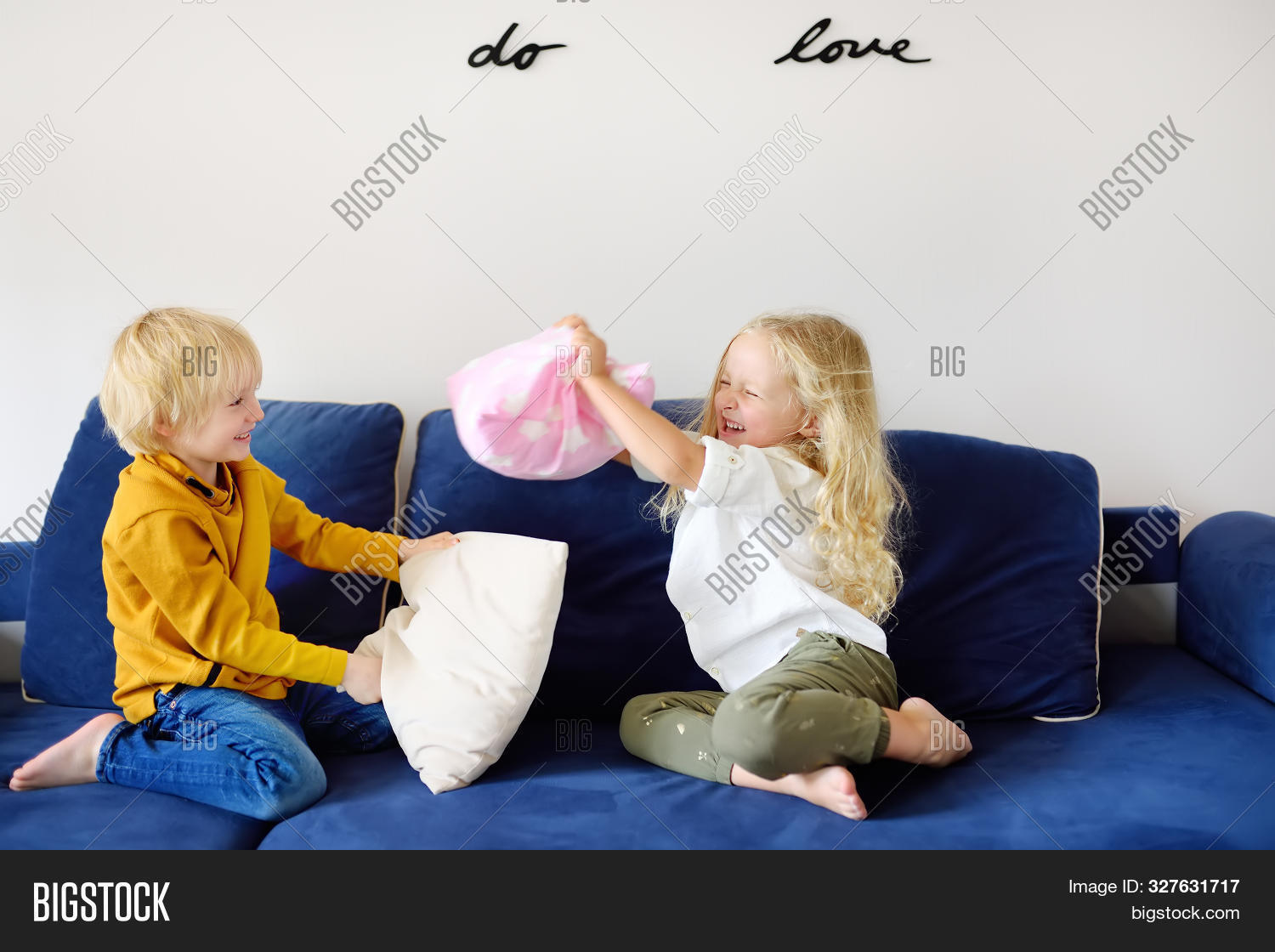 Pillow Fight. Mischievous Preschooler Children Jumping On A Sofa And ...