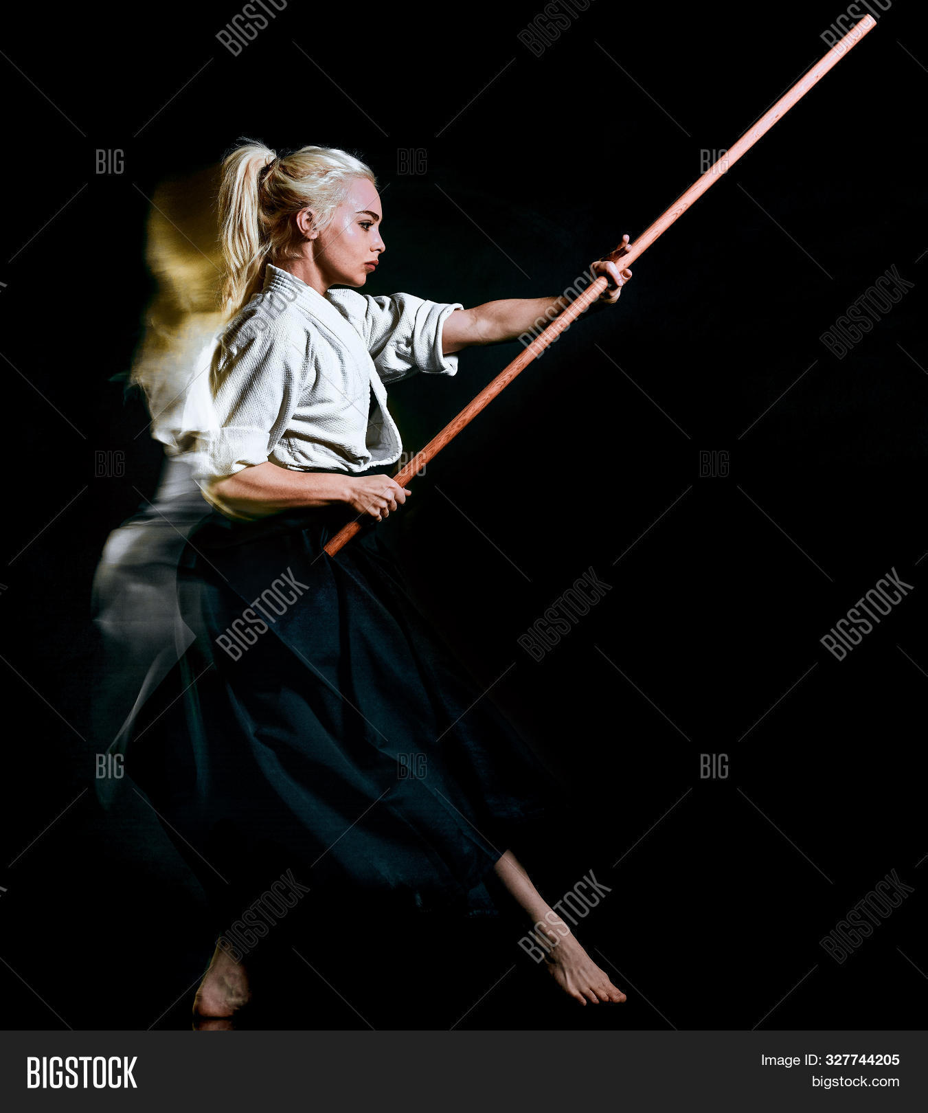 one caucasian bodoka fighters woman practicing Bo-Jutsu studio shot ...