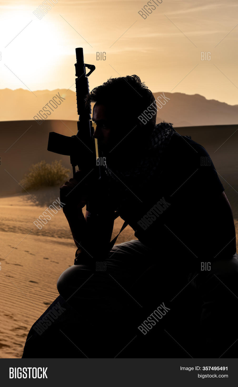 Silhouette of a male soldier resting in the shade on a desert and ...