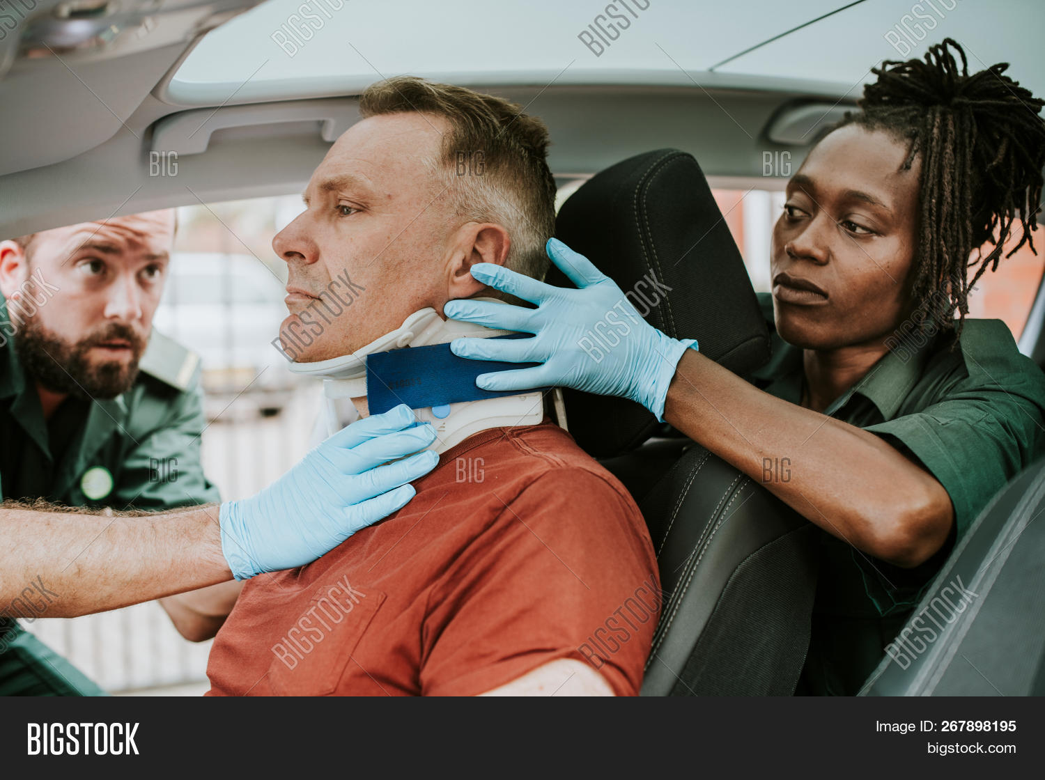 Paramedic placing a cervical collar to an injured man from car accident ...