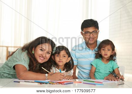 Indian mother, father and two their daughters drawing together - Stock Image - Everypixel