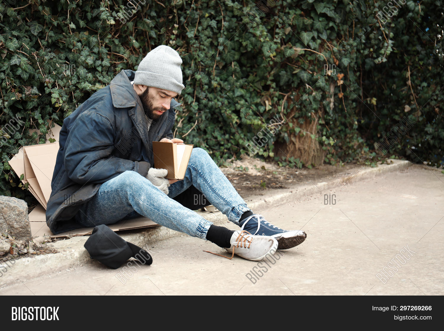 Poor Homeless Man With Book On Street In City image & stock photo ...