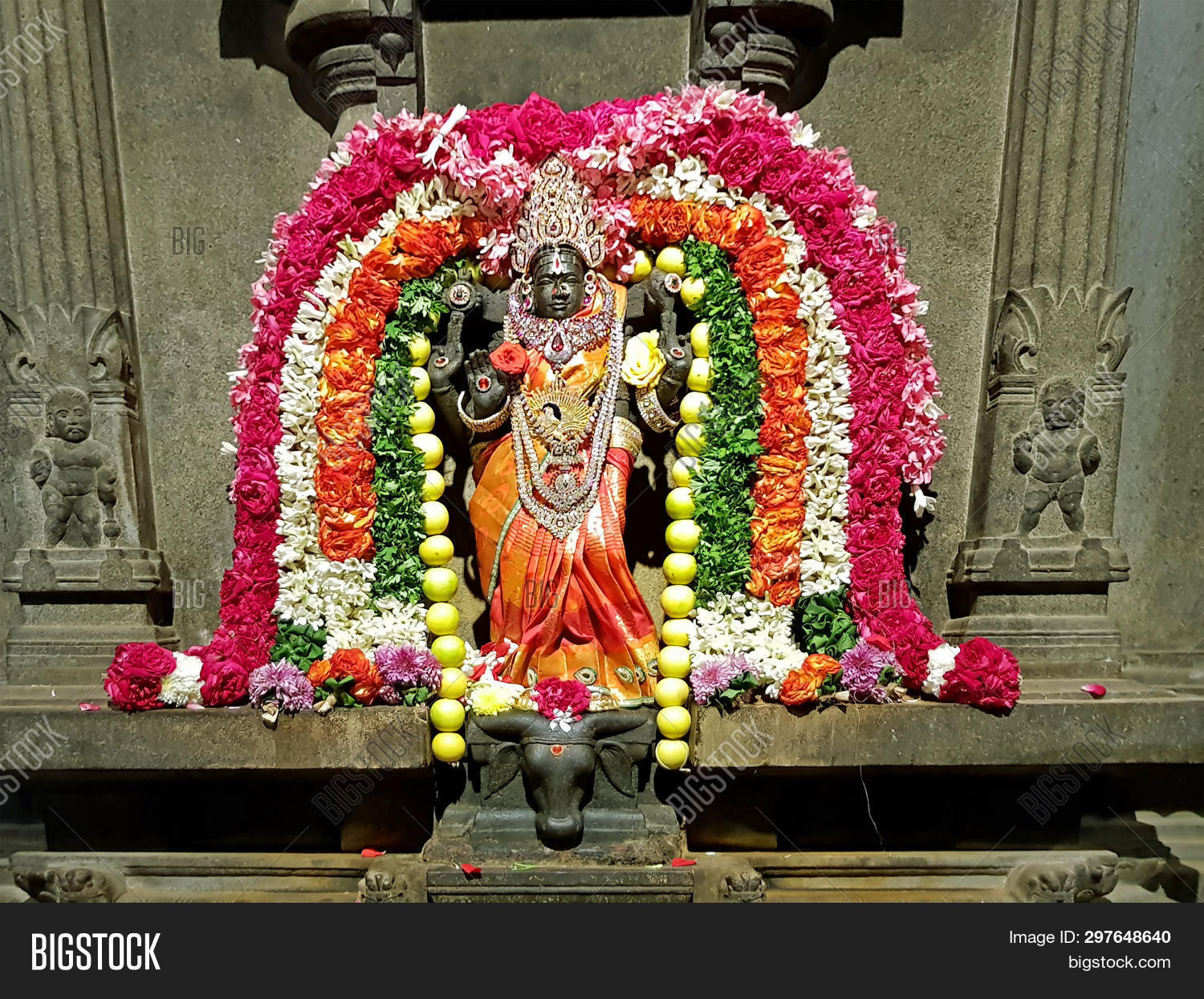 Ancient Durga statue decorated with flowers in the Sri Ramana Ashram in ...