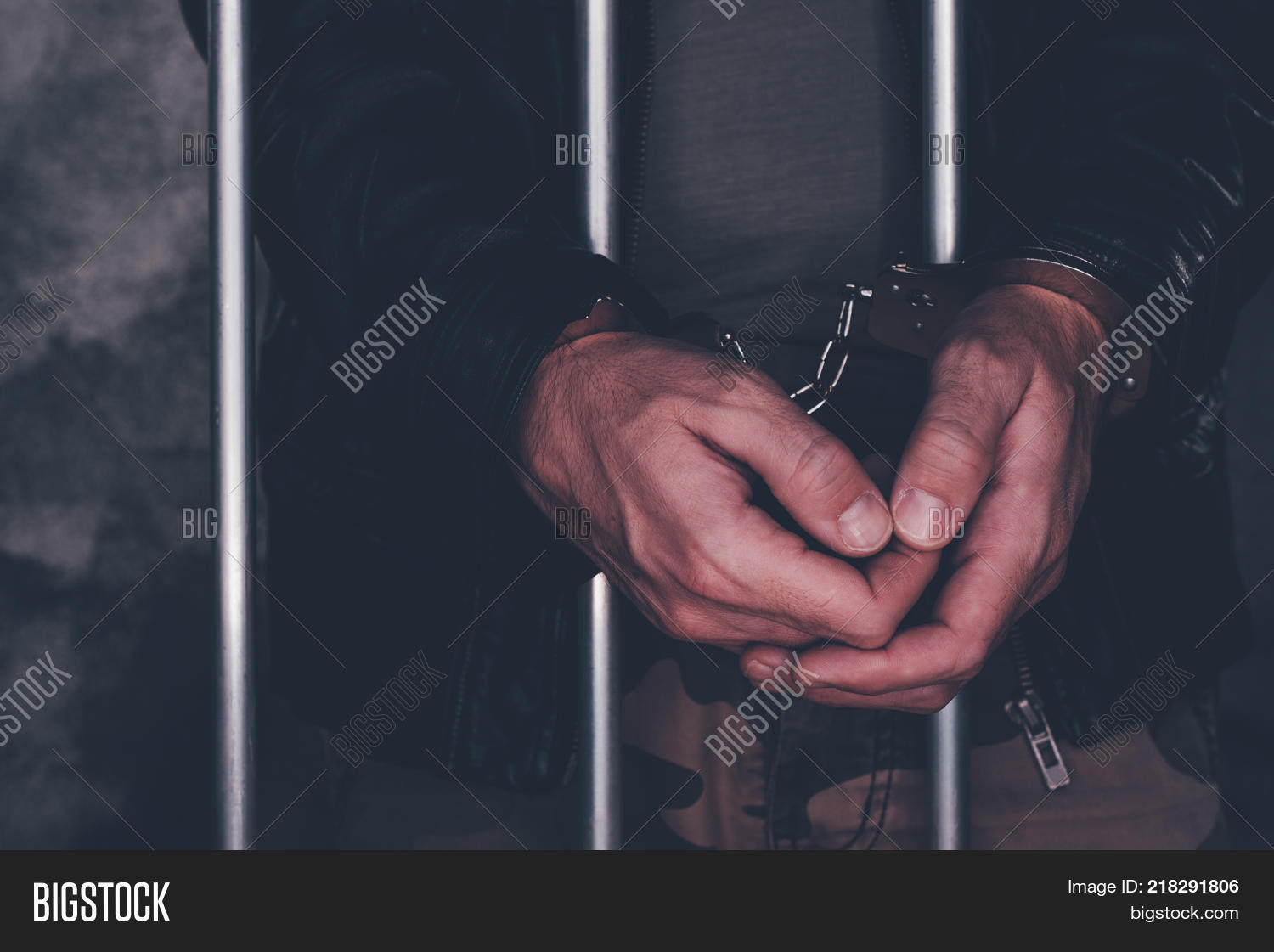 Handcuffed man behind prison b image & stock photo. 218291806