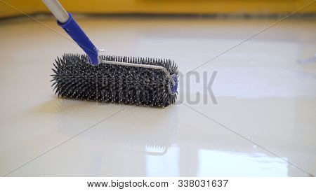 Worker Rolls Liquid Floor. Needle Roller For Bulk Floors. A Worker ...