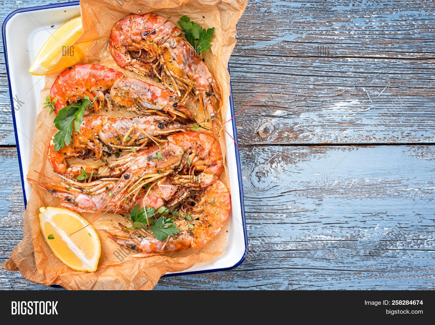 Traditional fried black tiger prawn with lemon as top view in a white ...