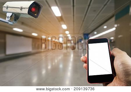 hand using mobile phone with blank screen and security camera system ...