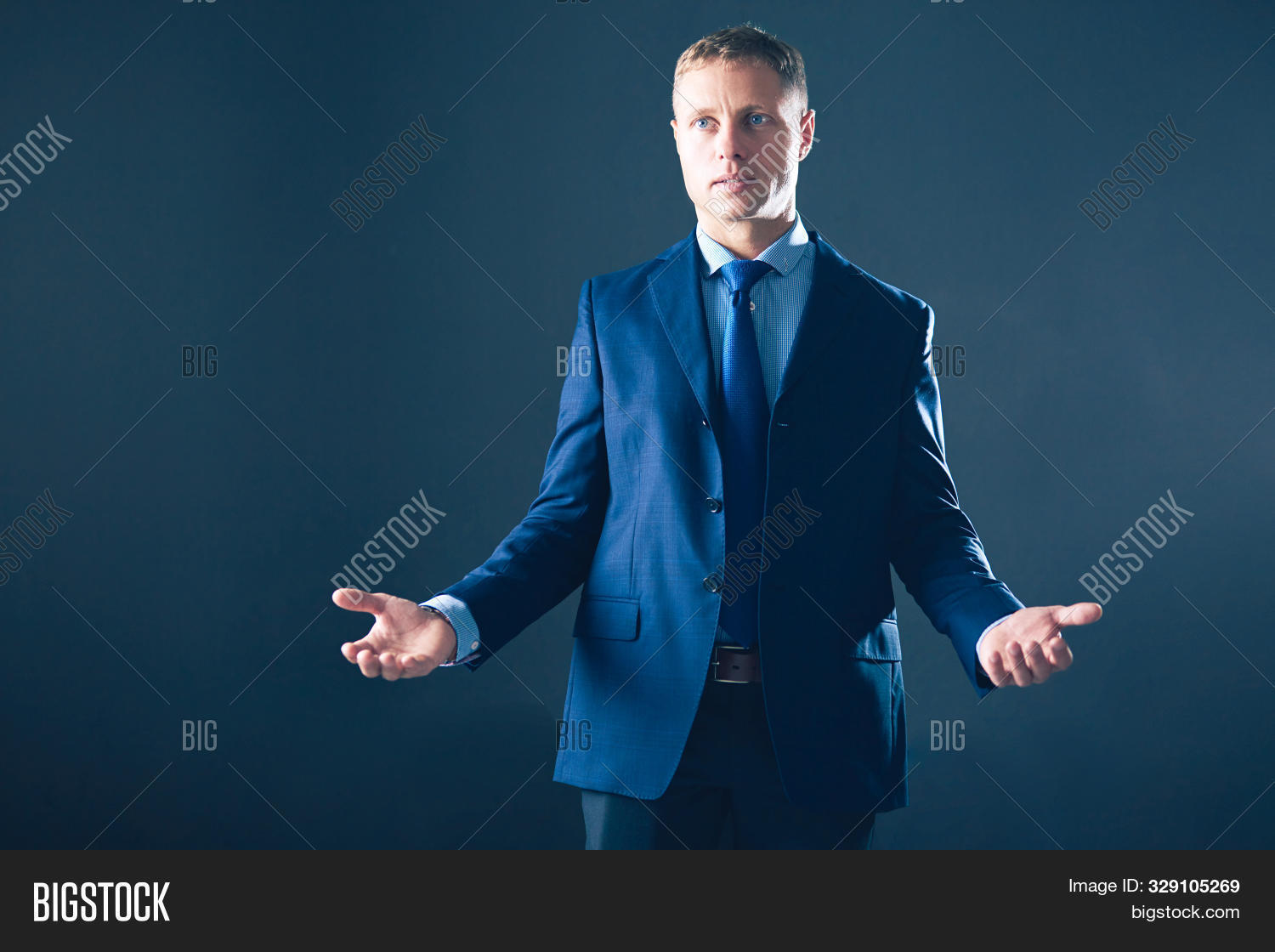 Portrait of successful cheerful cute young man presenting new product ...