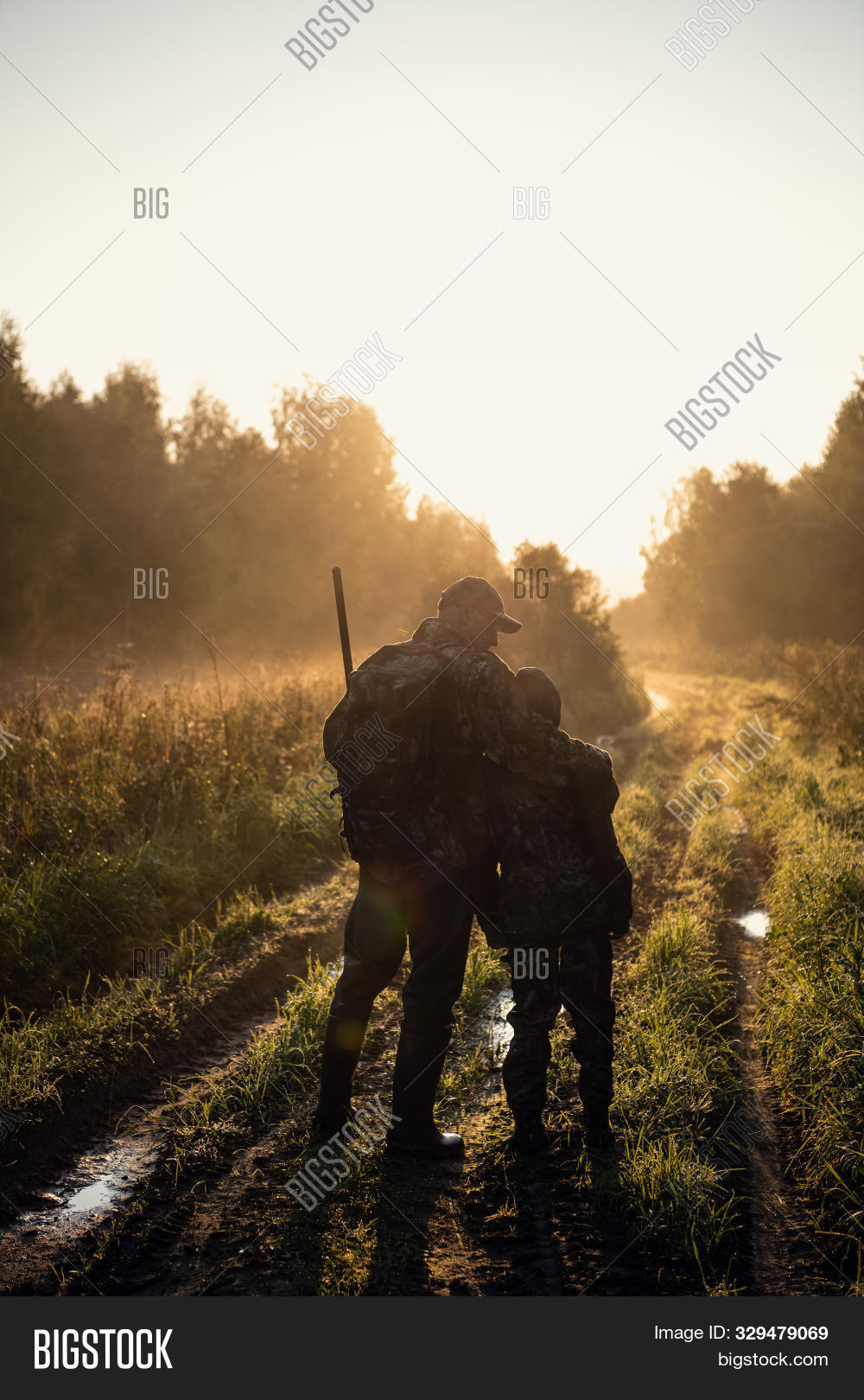 Rifle Hunter And His Son Silhouetted In Beautiful Sunset. Huntsman With ...