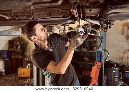 Repairman Fixing Car In Garage. Experienced Specialist Car Mechanic ...